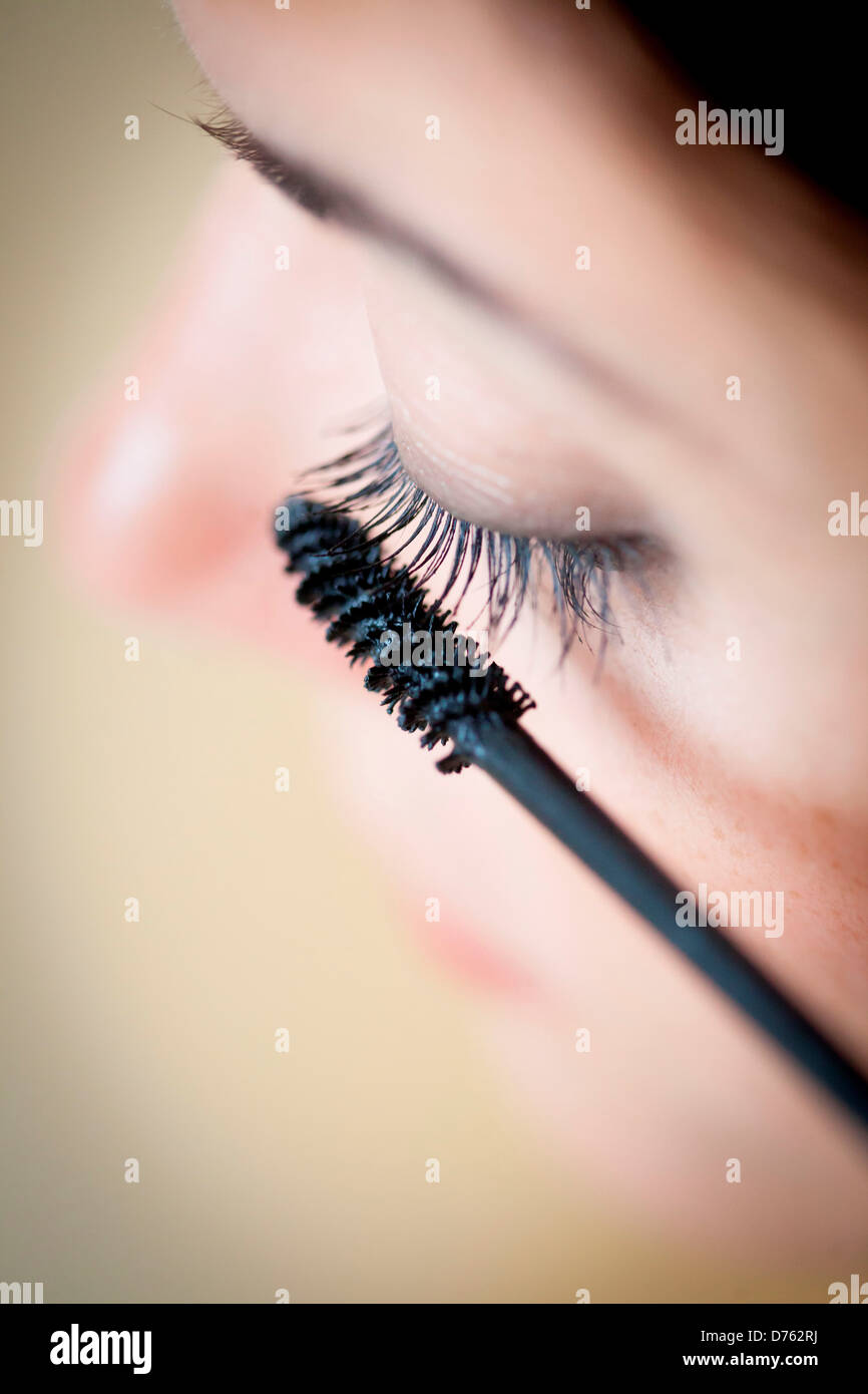Woman applying mascara on her eyelashes Stock Photo - Alamy