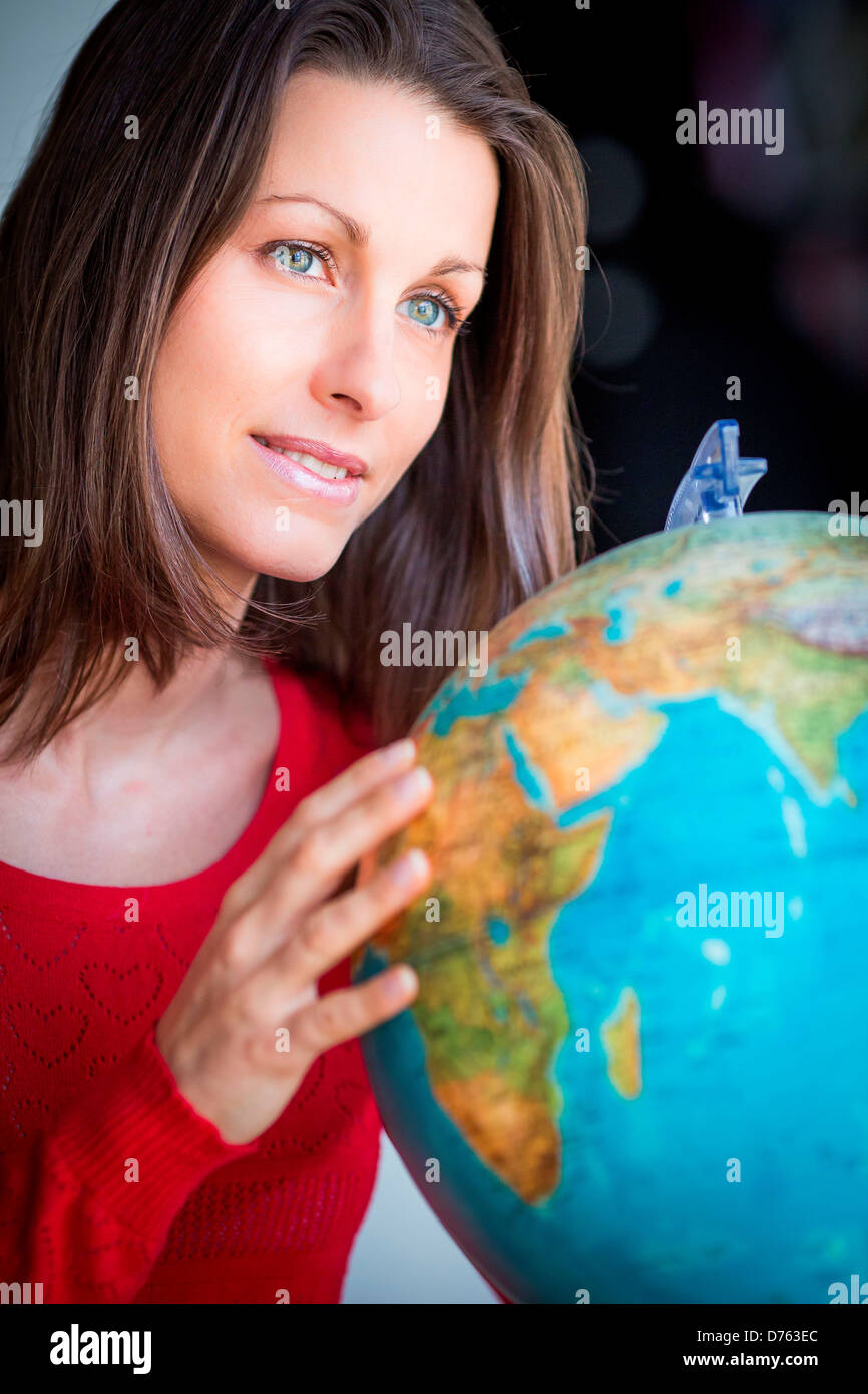 Woman looking at a map of the world Stock Photo - Alamy