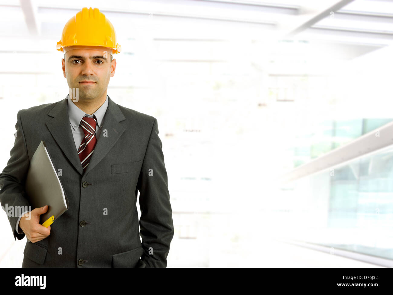 An engineer with yellow hat inside a modern building Stock Photo - Alamy