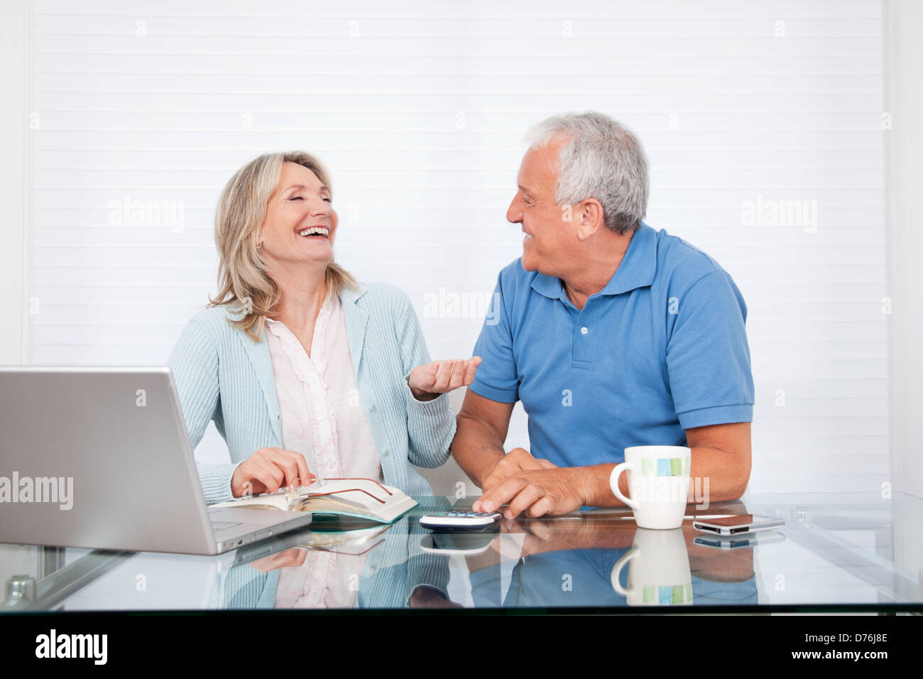 Couple At Dining Table Working on Laptop Stock Photo - Alamy