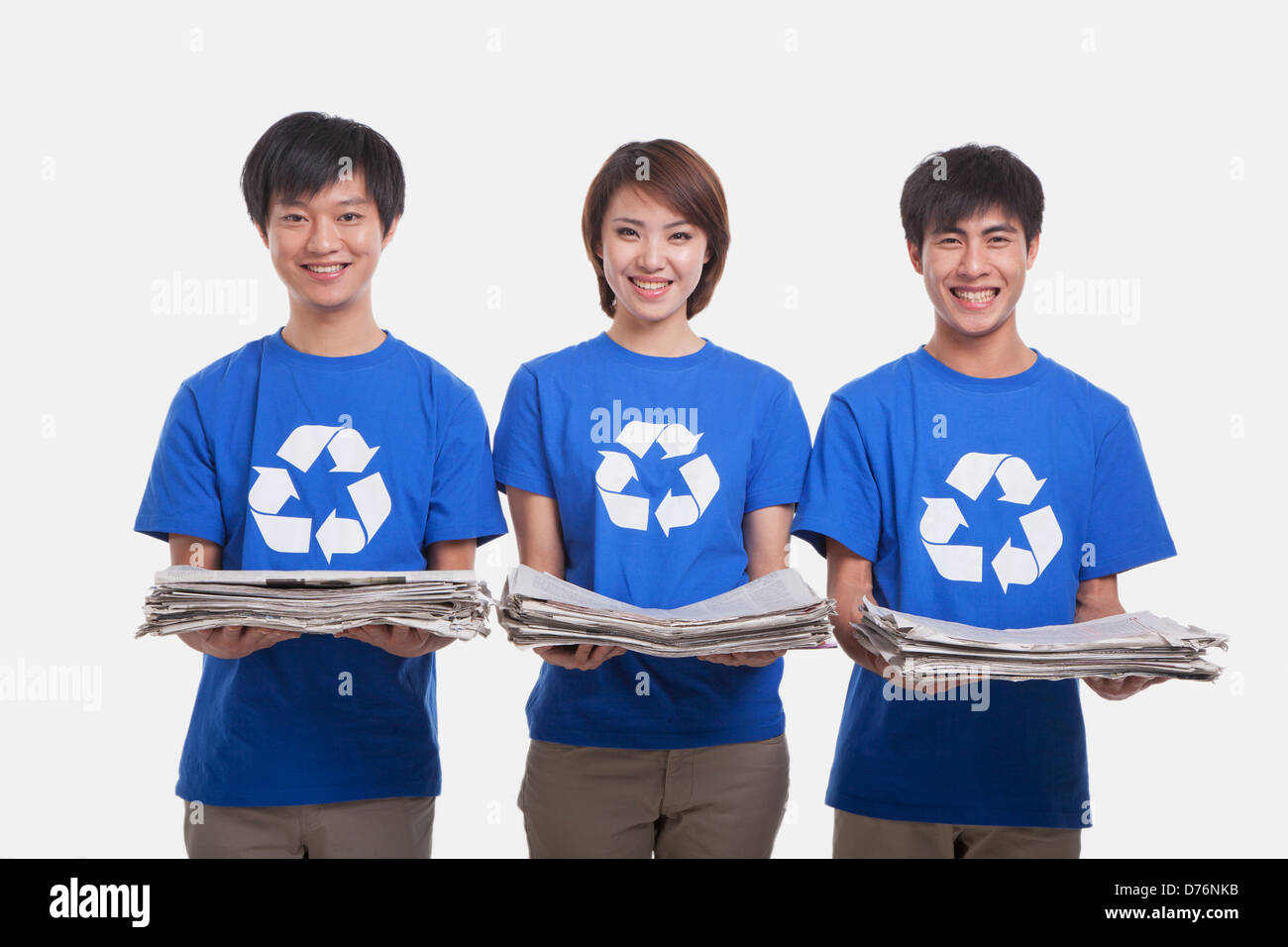 Three young people carrying newspapers, studio shot Stock Photo - Alamy