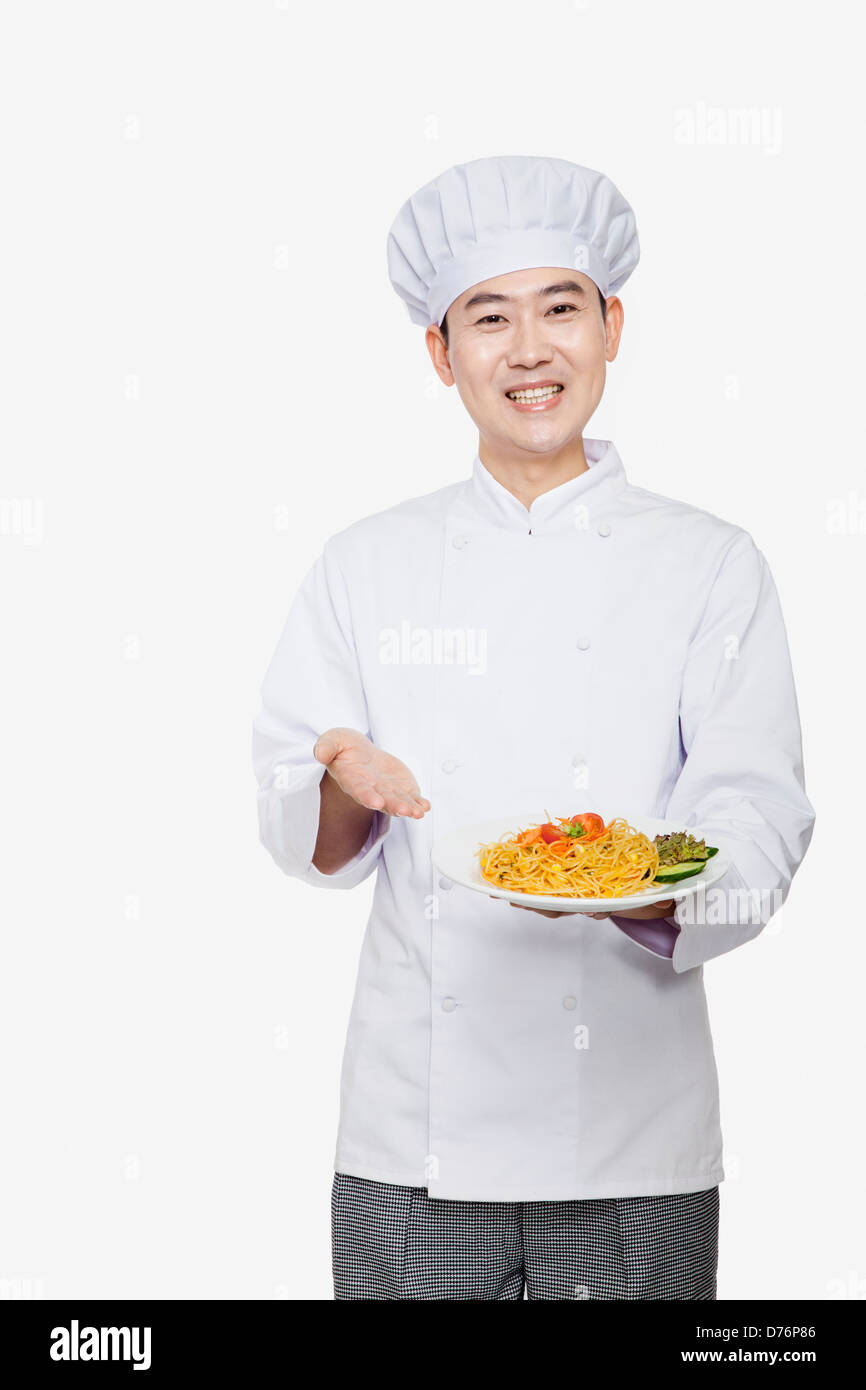 Chef showing prepared food, studio shot Stock Photo - Alamy