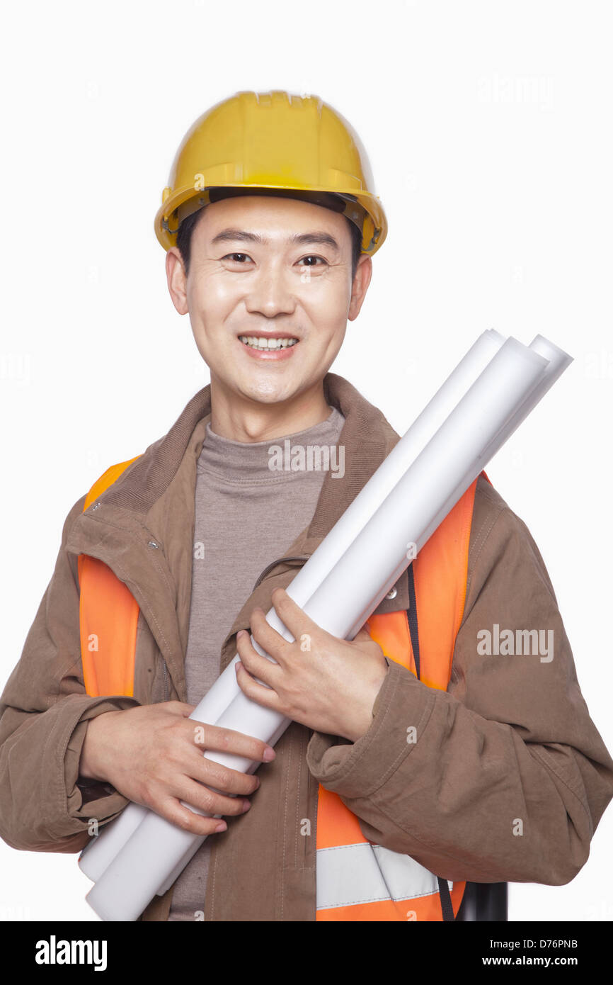 Construction worker holding blueprint against white background ...