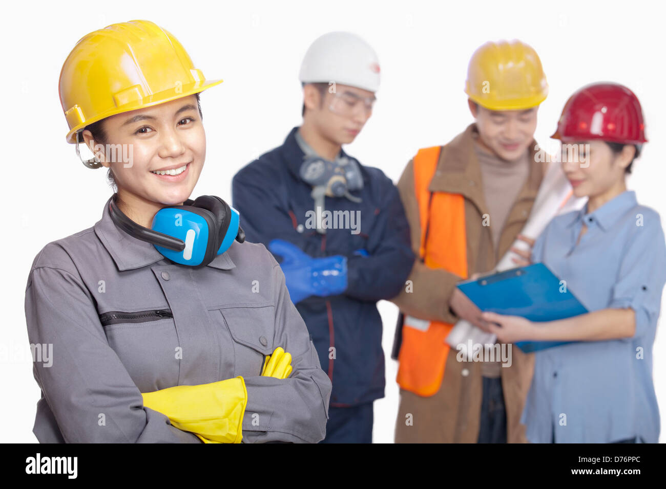 Four construction workers against white background, focus in foreground ...