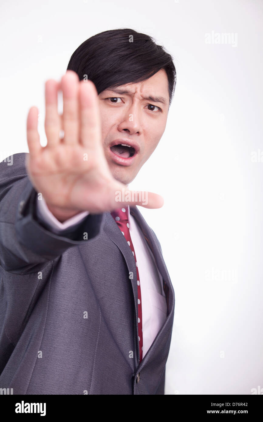 Young businessman with hand raised in stop gesture, studio shot Stock ...