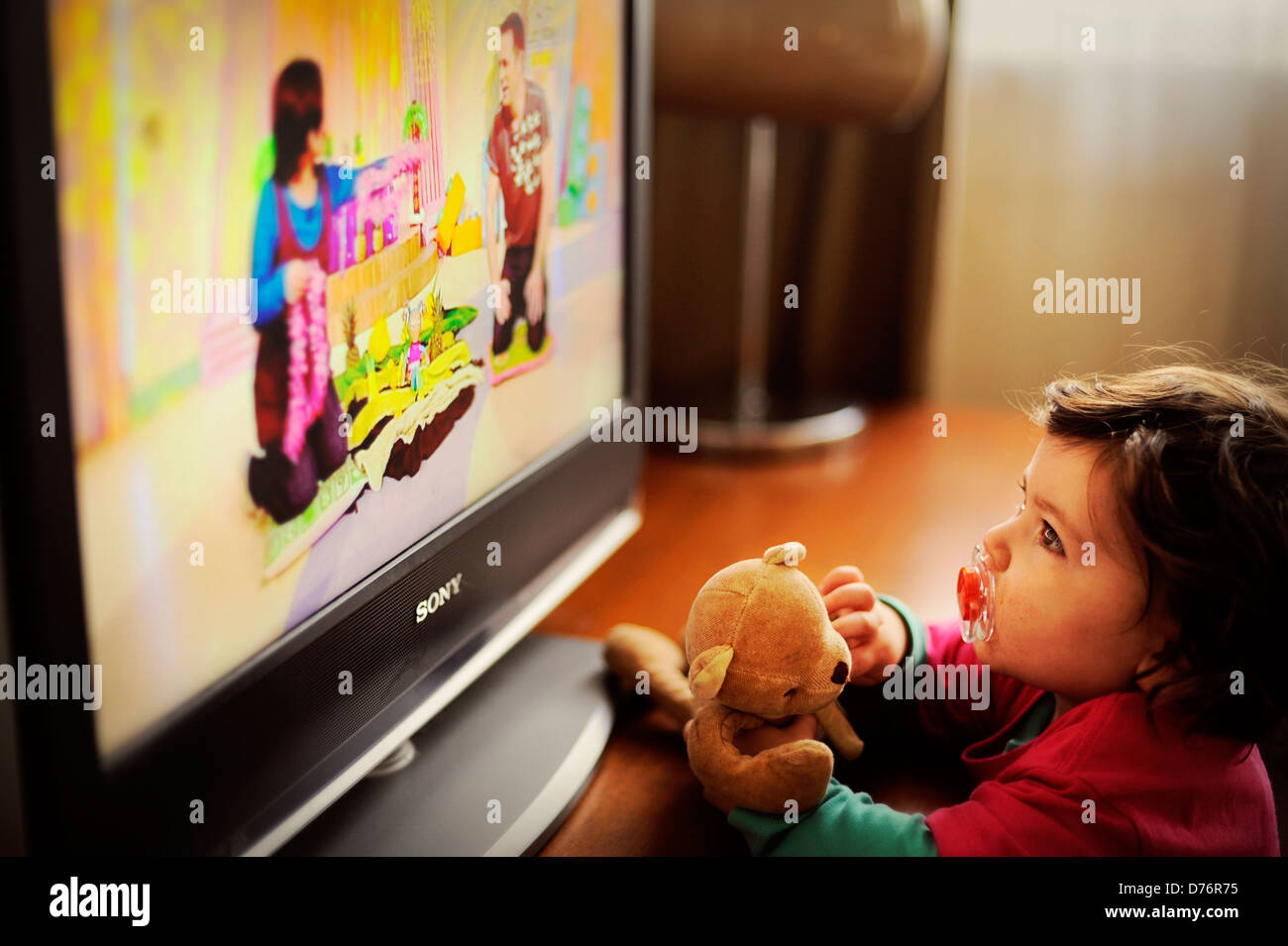 Toddler / Child watching TV with teddy bear and dummy Stock Photo - Alamy