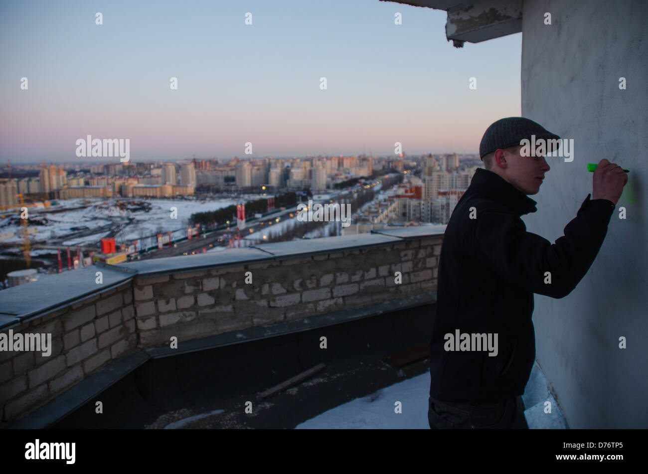 Sunset city roof. Writing graffiti on the roof wall at the sunset with ...