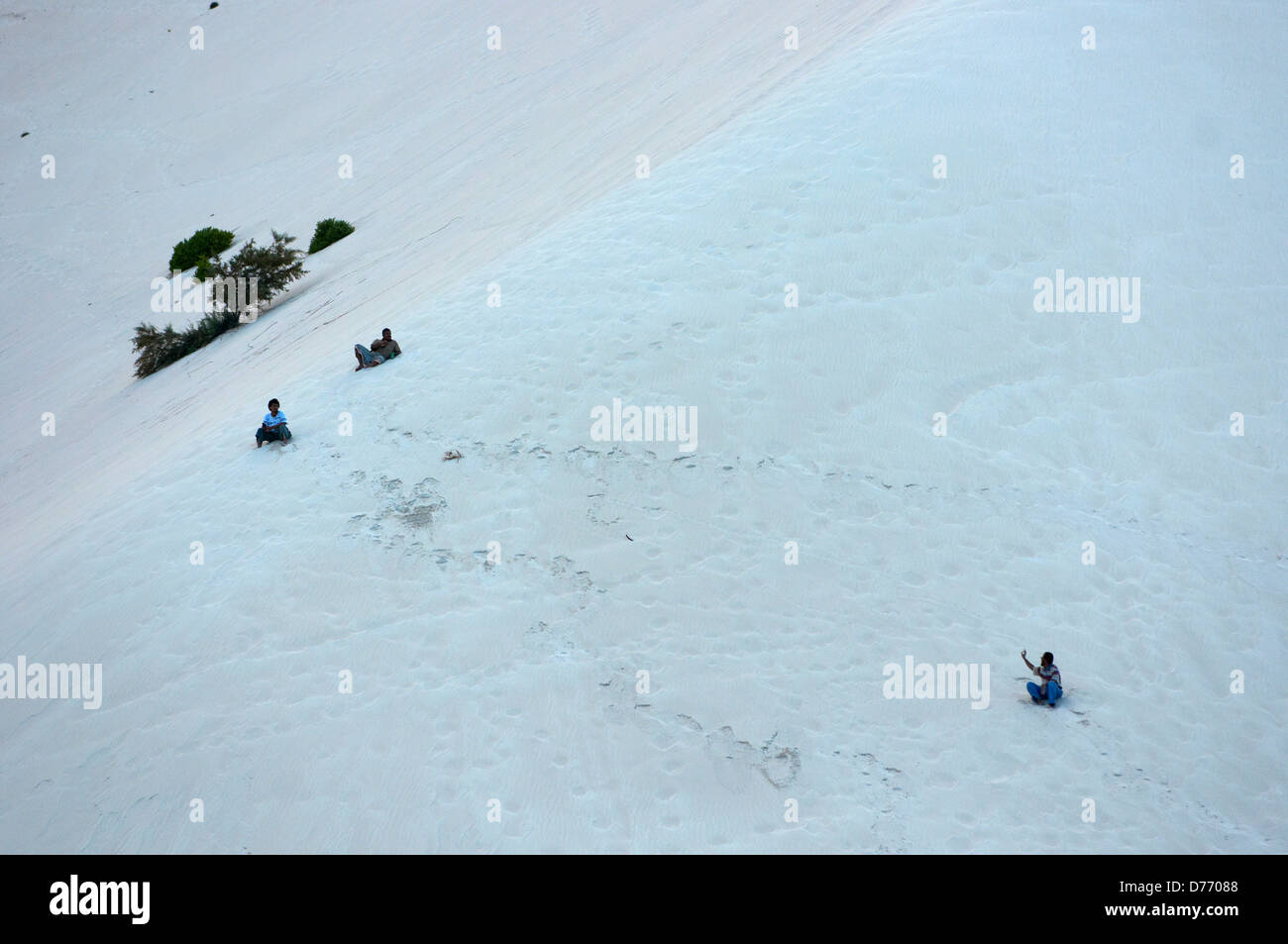 Some local people siting on the huge sand dune of Arher beach, Socotra ...