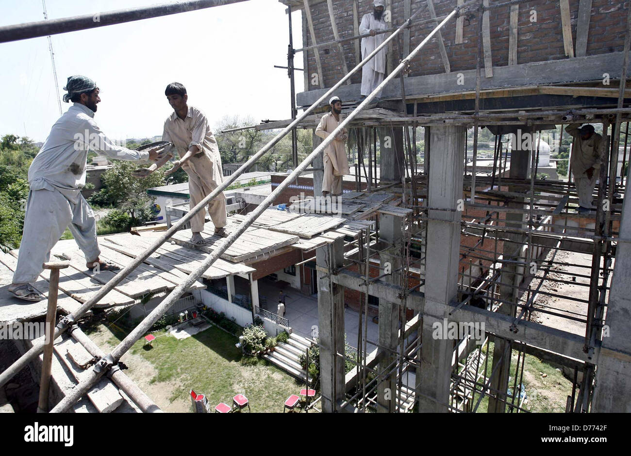 Laborer busy in construction work of a residential building as the ...