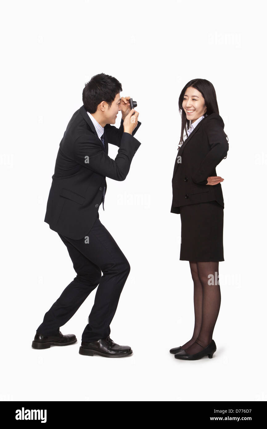 Businessman photographing businesswoman Stock Photo - Alamy