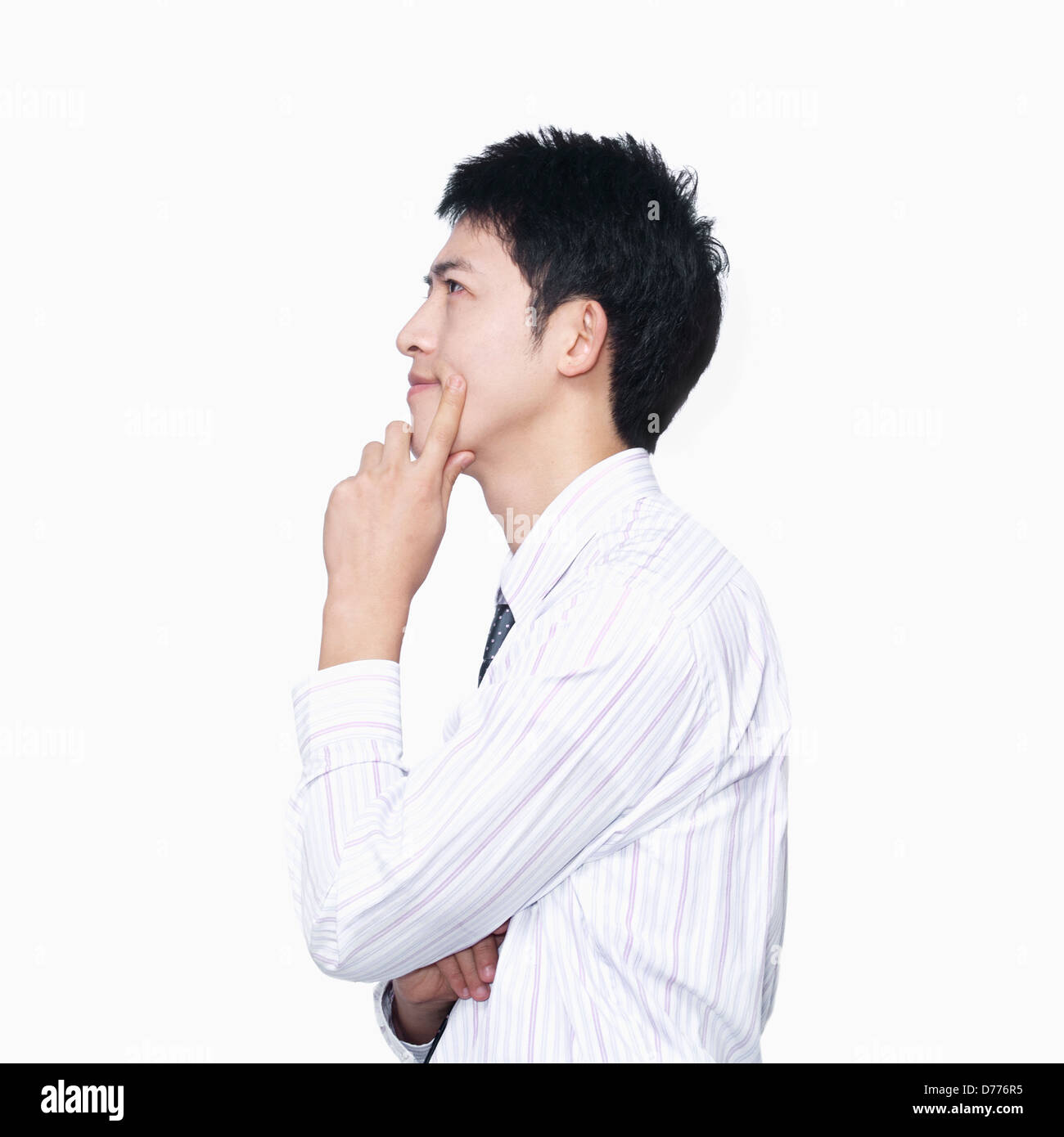 Businessman with hand on chin thinking Stock Photo - Alamy