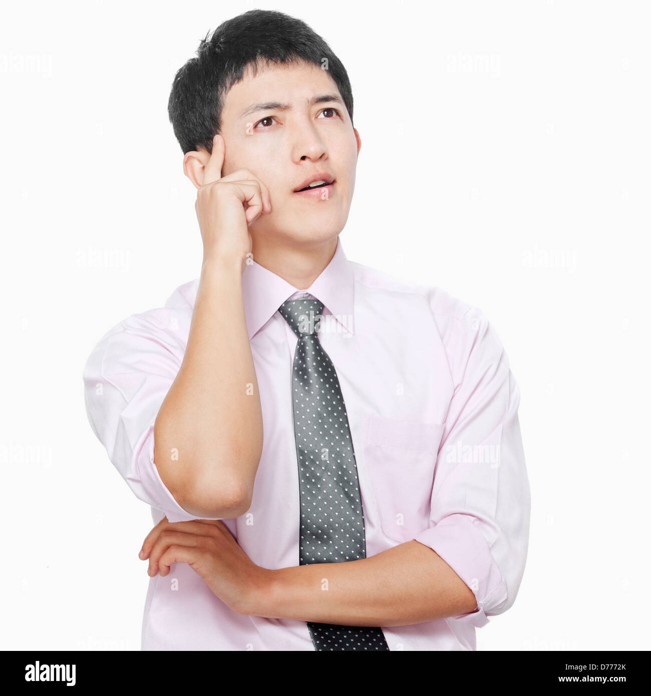 Young man with hand on face thinking Stock Photo - Alamy