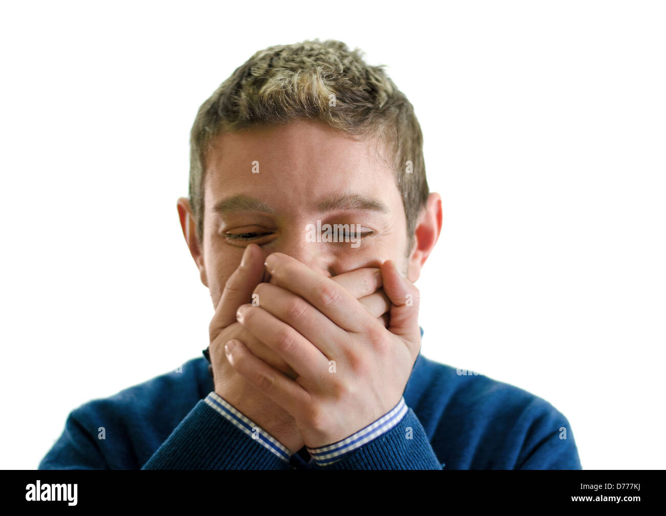Young Man Covering His Mouth With Hands Trying Not To Laugh Stock