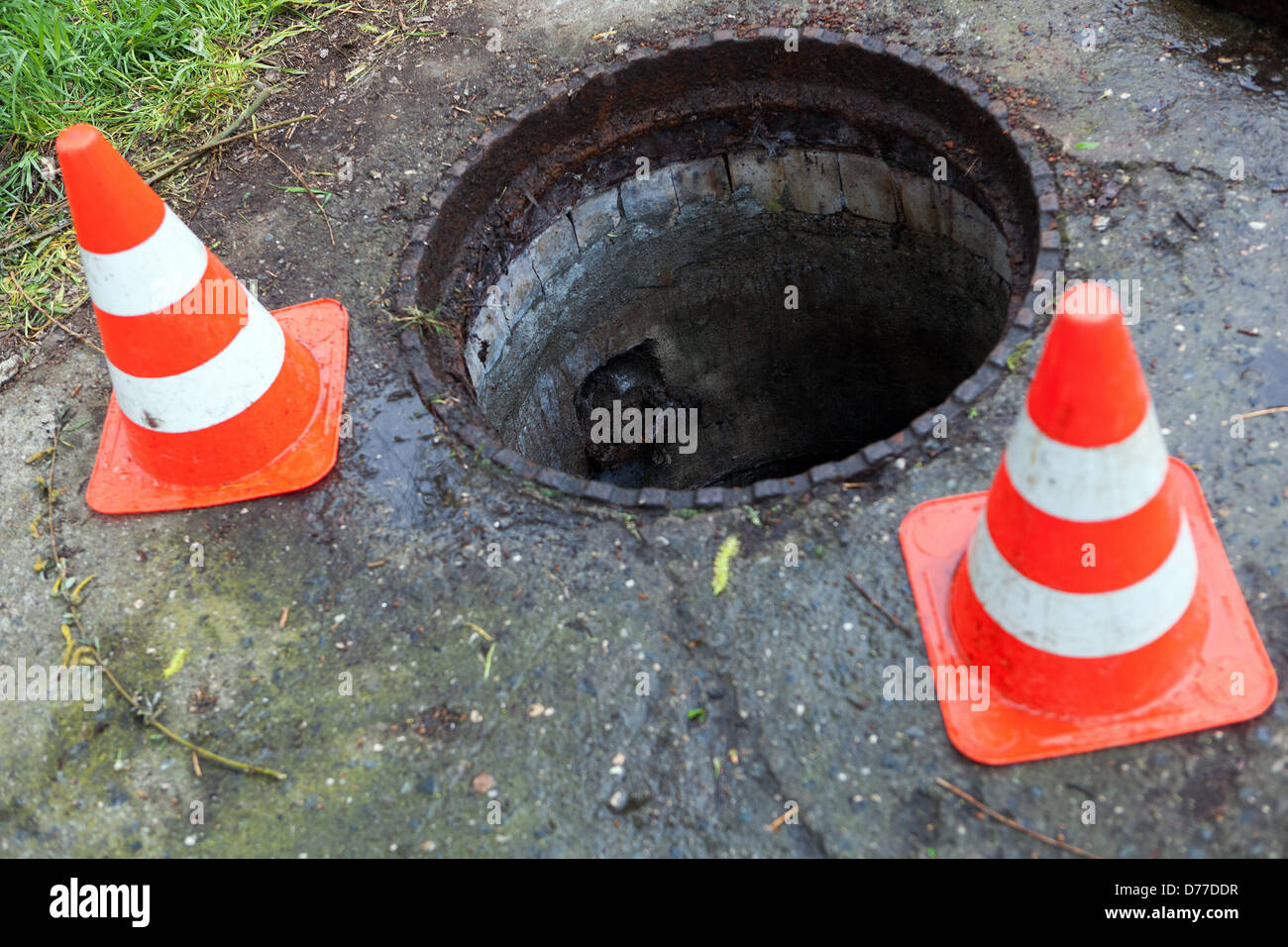 Open manhole cover, Danger of falling into a hole, cones Stock Photo ...