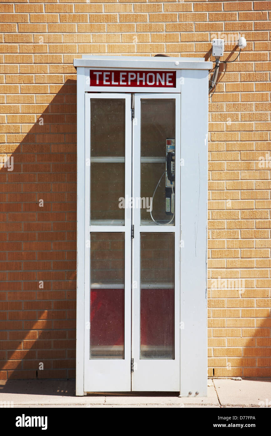 Telephone booth set against brick wall Stock Photo - Alamy