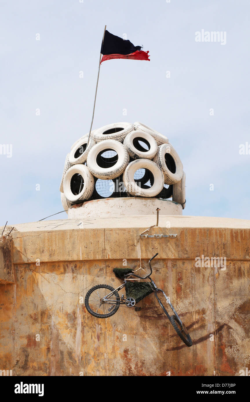 Flag on adorned structure at Slab City campsite near town Niland ...