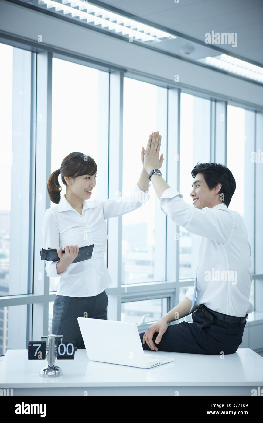 businessman and businesswoman in office doing high five Stock Photo - Alamy