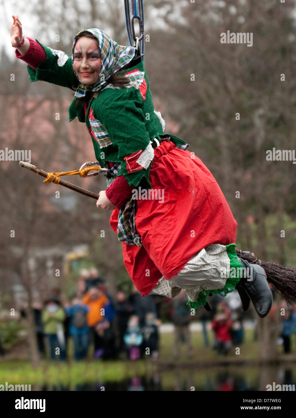 A woman dressed as a witch performs a witches' flight in a broomstick ...