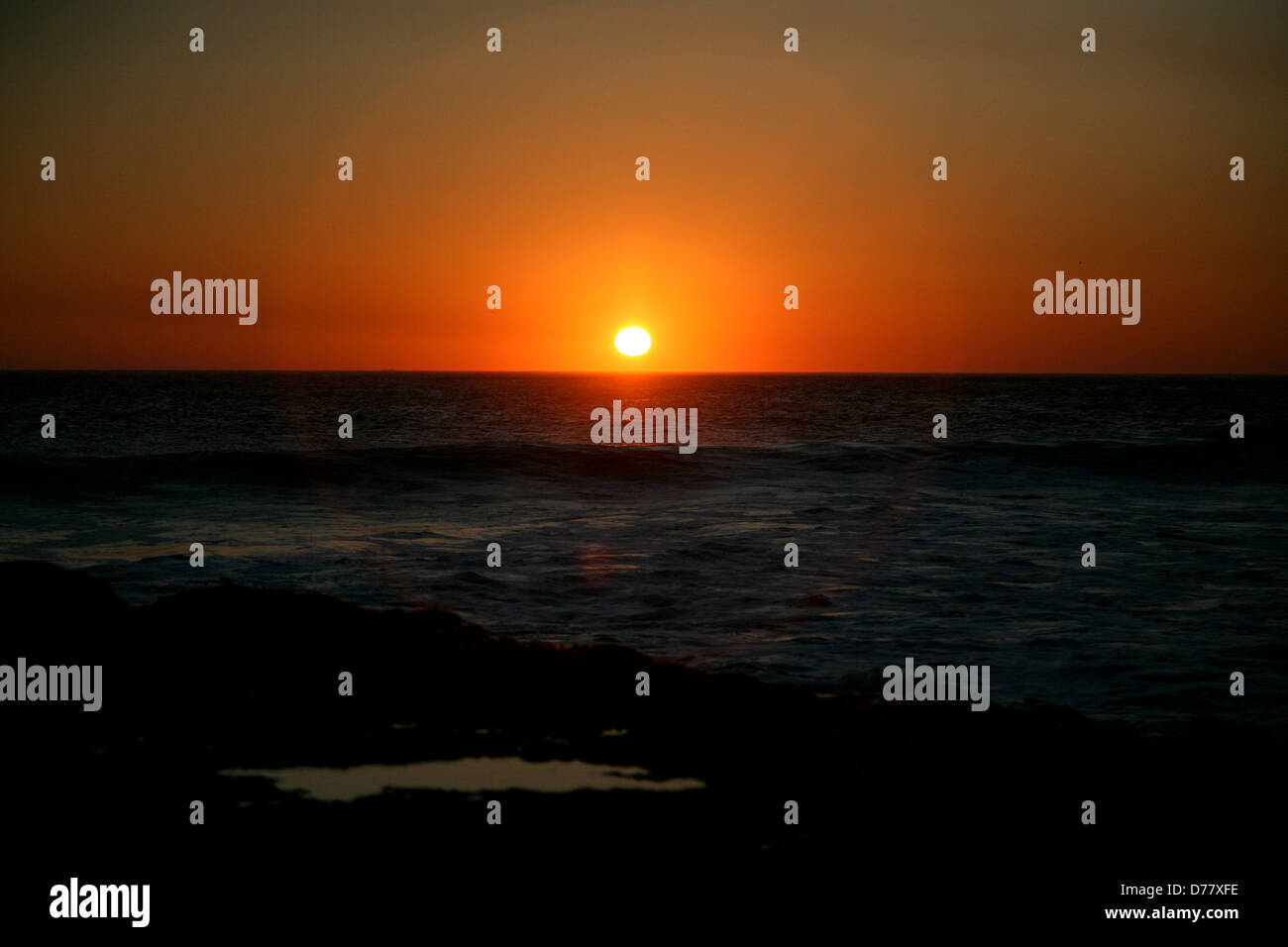 Sun sets over water Stock Photo - Alamy