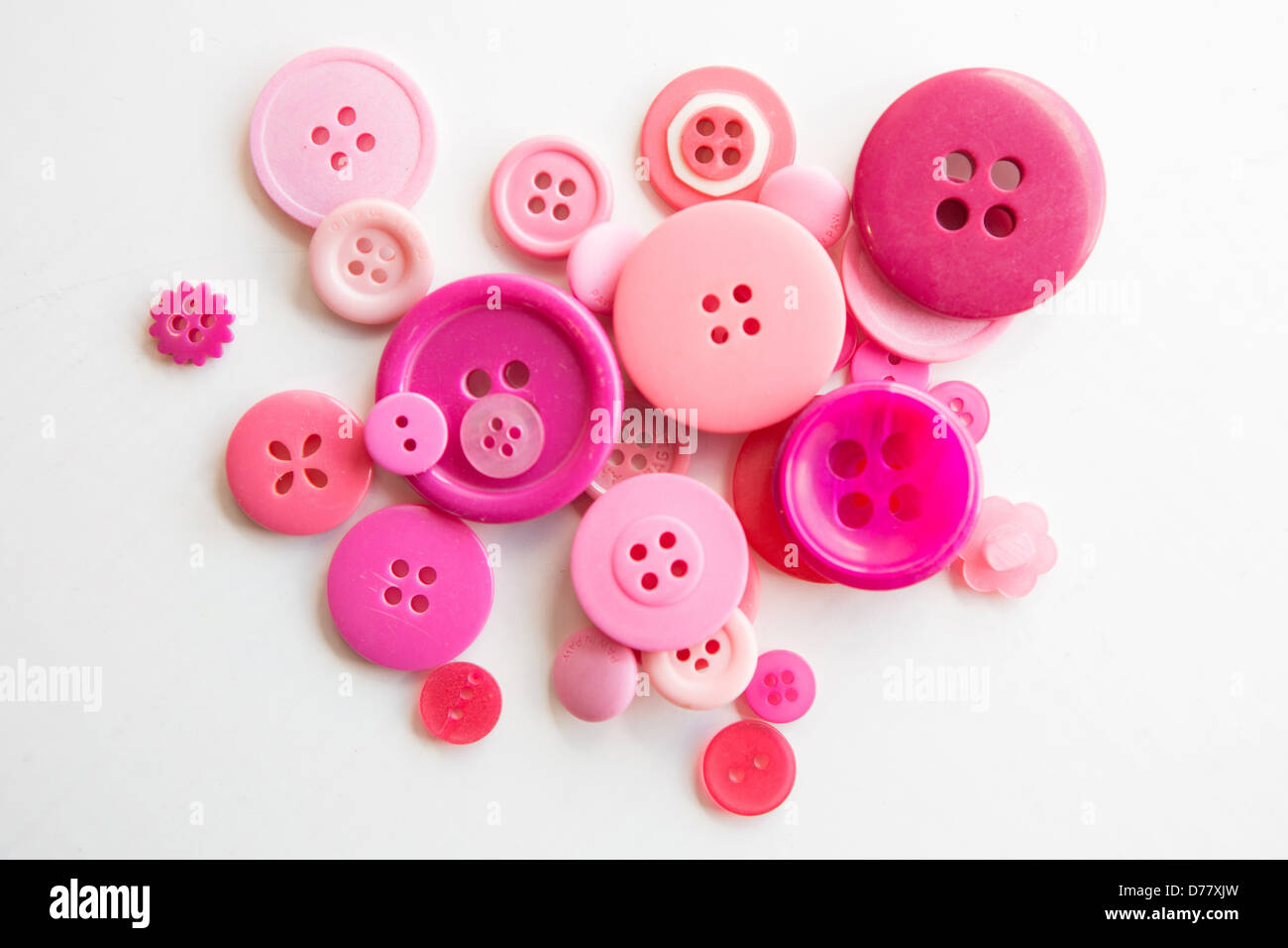 A handful of pink buttons on a light grey background Stock Photo - Alamy