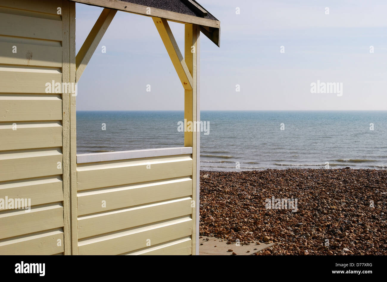 Beige painted beach hut at Rustington. West Sussex. England with sea in ...