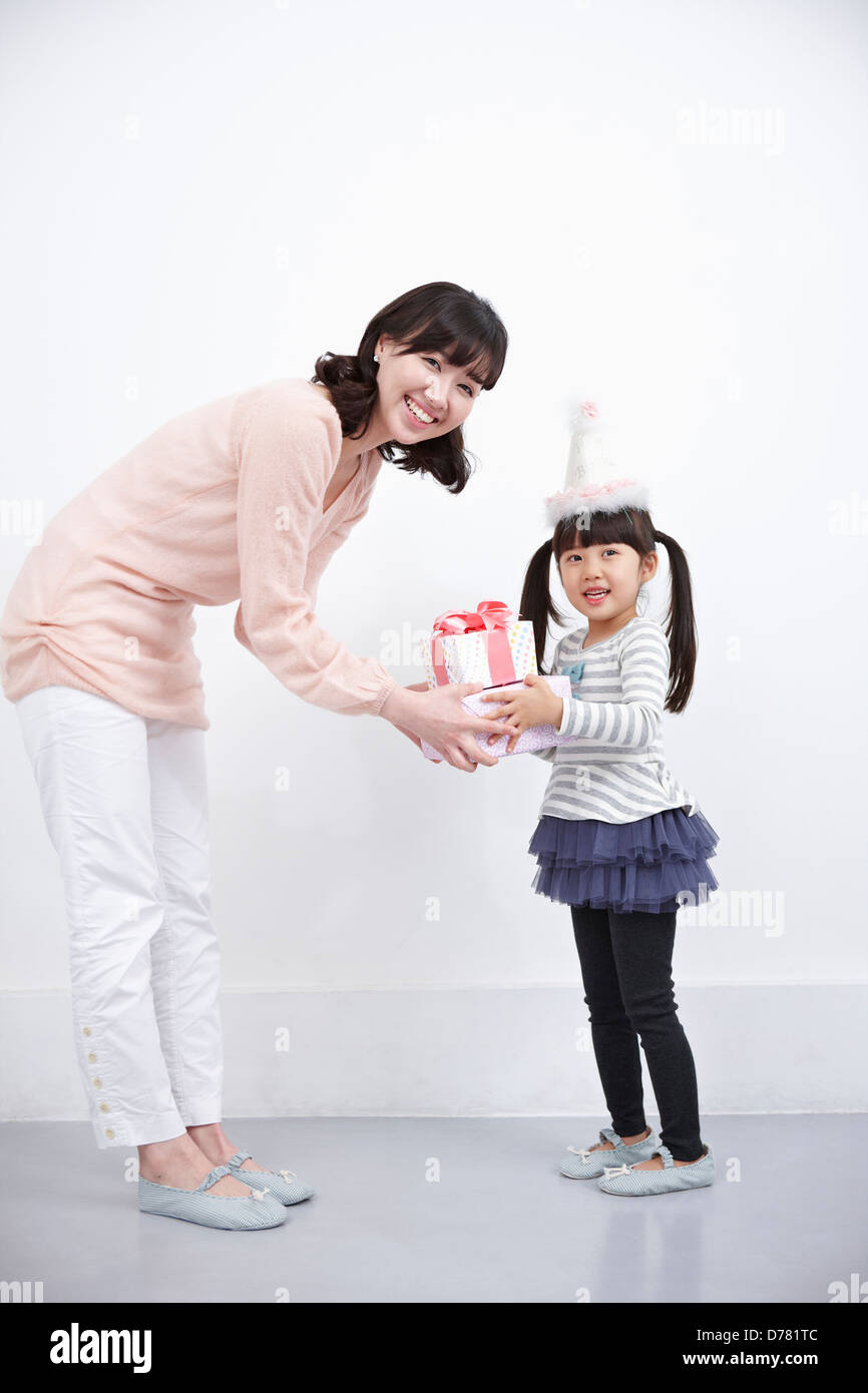 mother giving a present to a birthday girl Stock Photo - Alamy