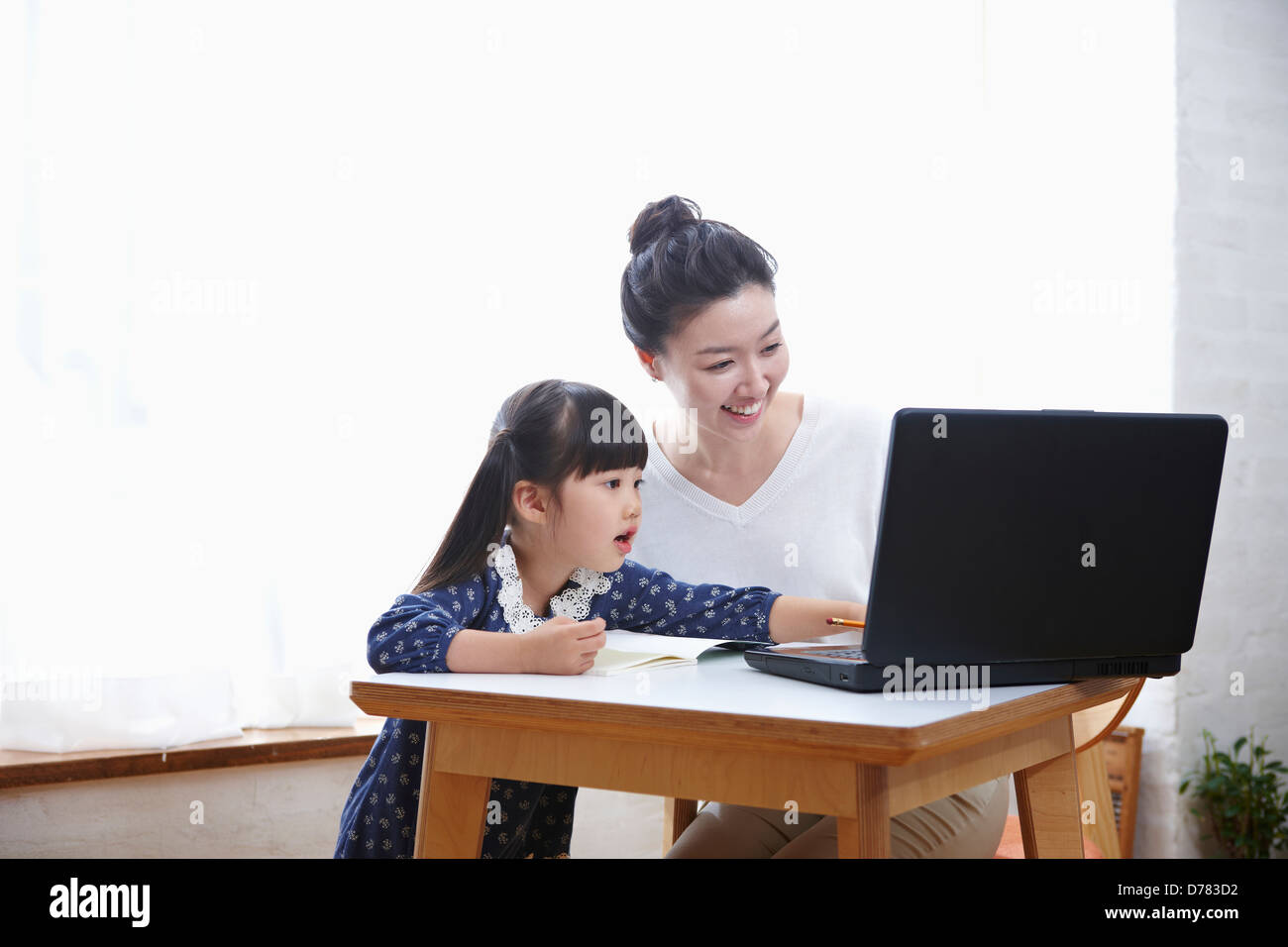 mother and daughter looking at laptop screen together Stock Photo - Alamy