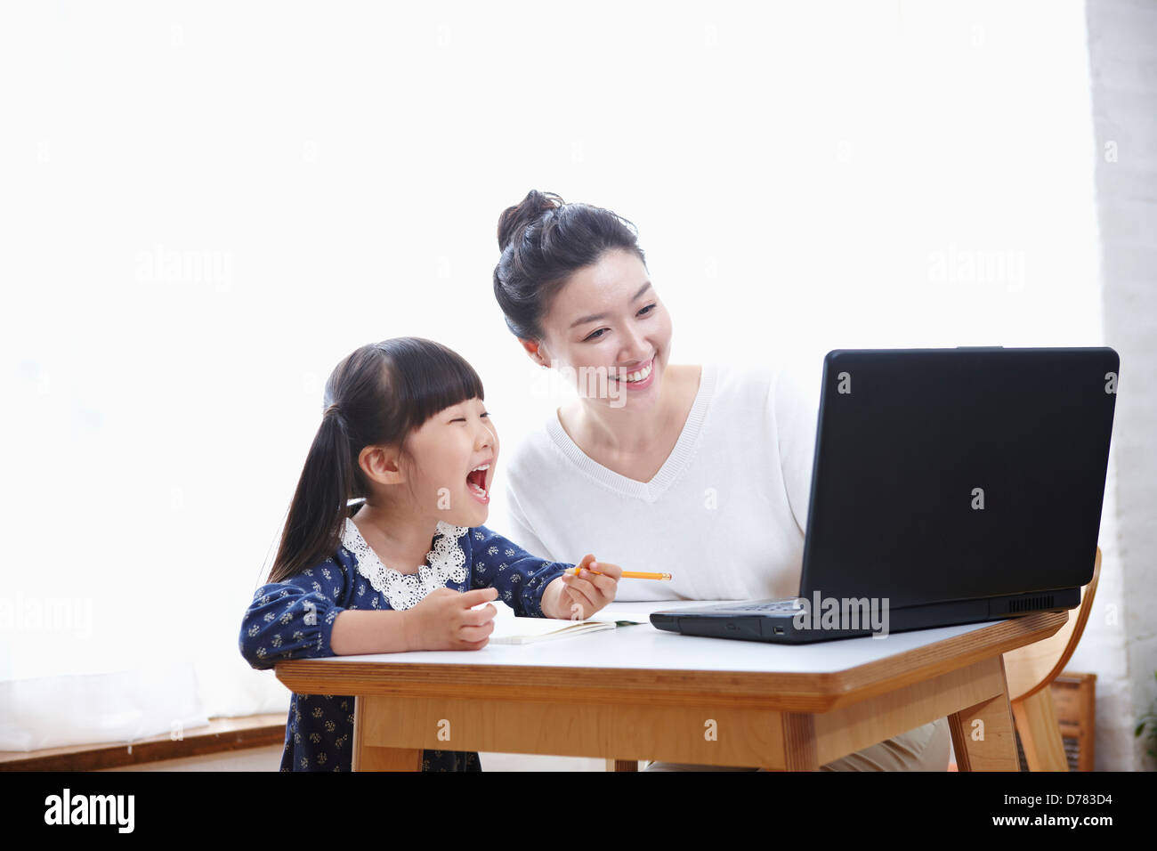 mother and daughter looking at laptop screen together Stock Photo - Alamy