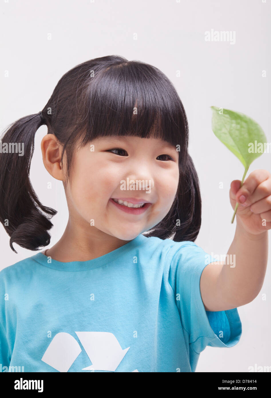 Little girl looking at leaf, close up studio shot Stock Photo - Alamy