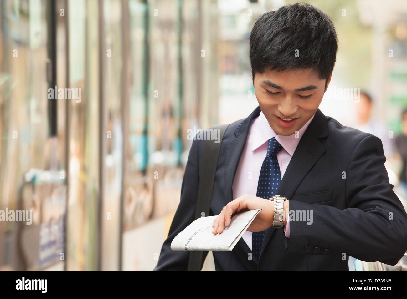 Young Businessman checking the time, waiting for the bus Stock Photo ...