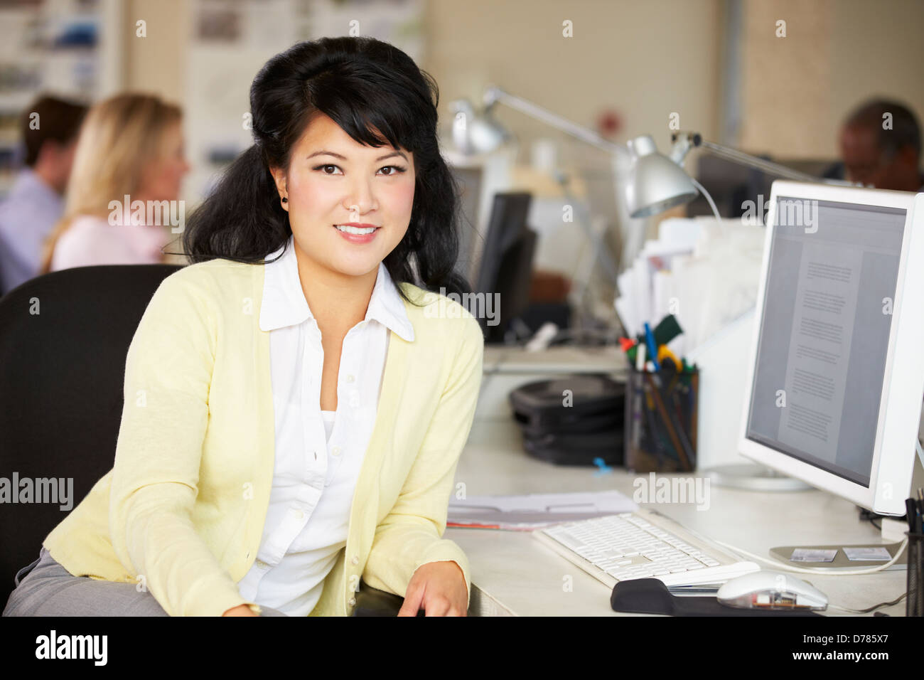 Woman Working At Desk In Busy Creative Office Stock Photo - Alamy