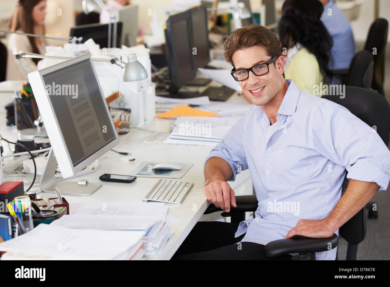 Man Working At Desk In Busy Creative Office Stock Photo - Alamy
