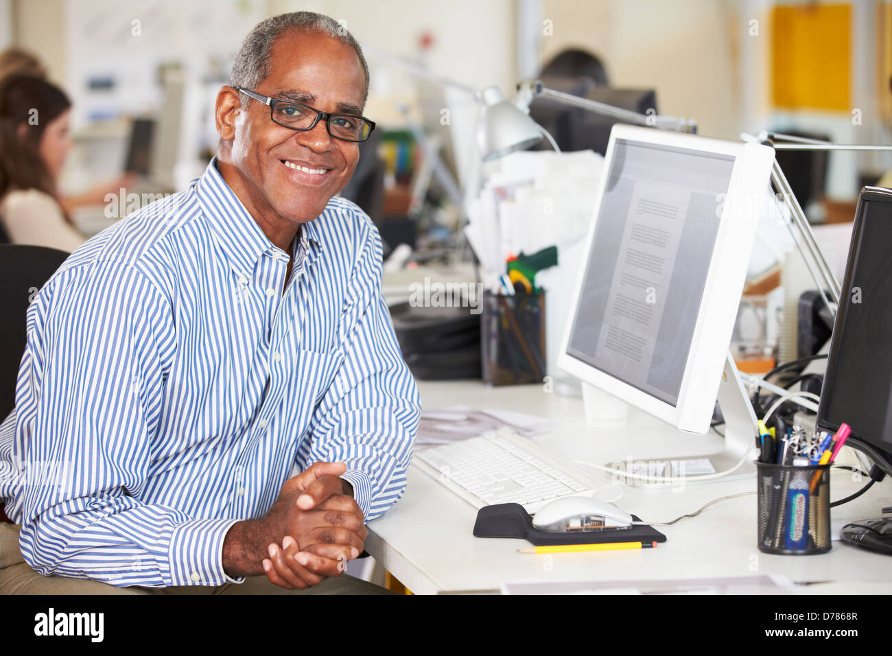 Man Working At Desk In Busy Creative Office Stock Photo - Alamy