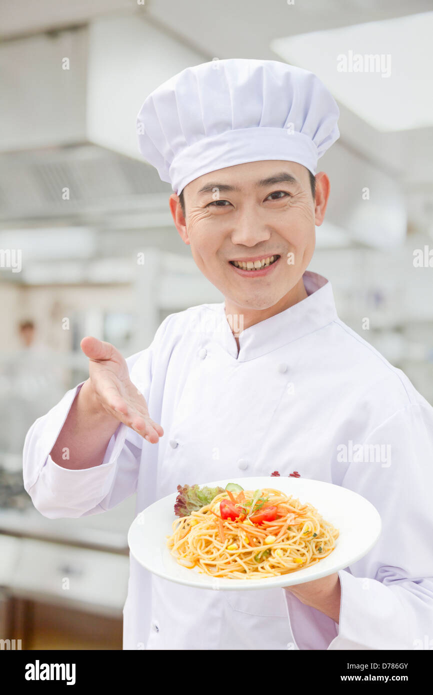 Chef showing prepared food Stock Photo - Alamy