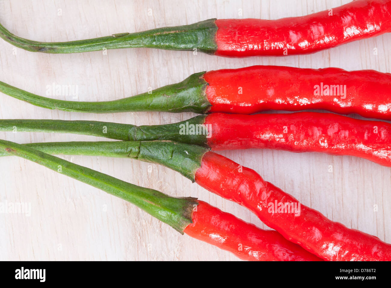 Red hot chili peppers on wooden table Stock Photo - Alamy