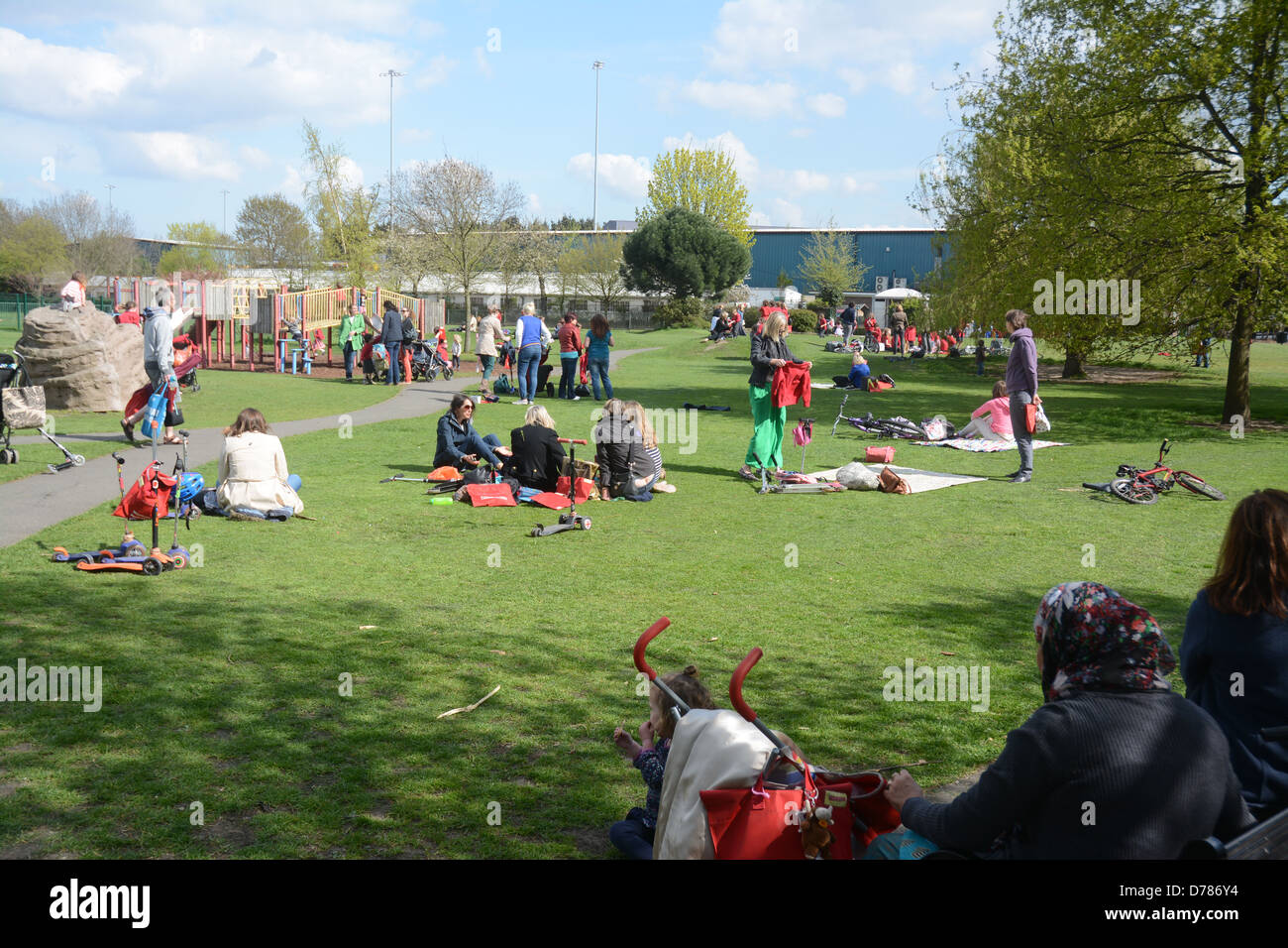 Parents and primary schoolchildren play in a park after school on a ...