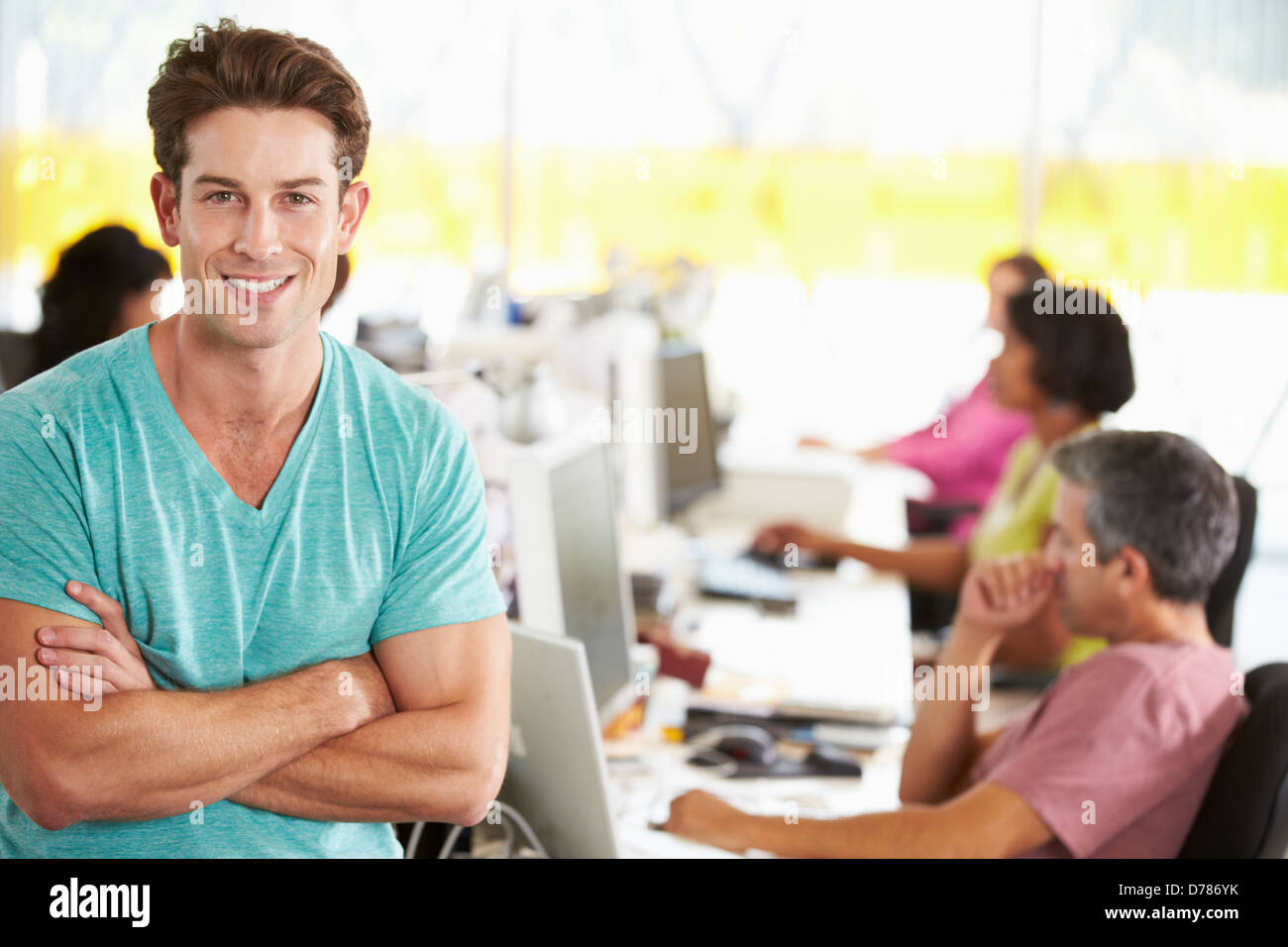 Portrait Of Man Standing In Busy Creative Office Stock Photo - Alamy