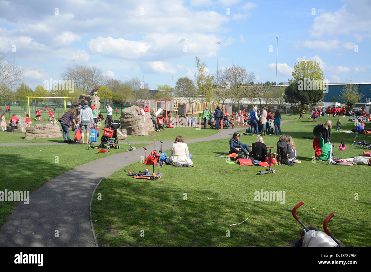 Parents and primary schoolchildren play in a park after school on a ...