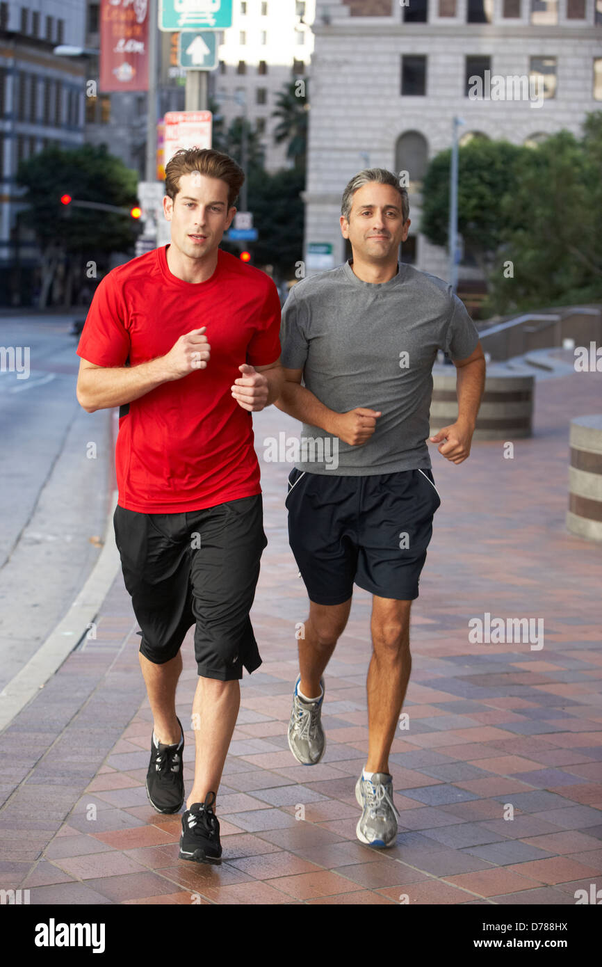 Two Men Running On Urban Street Stock Photo - Alamy