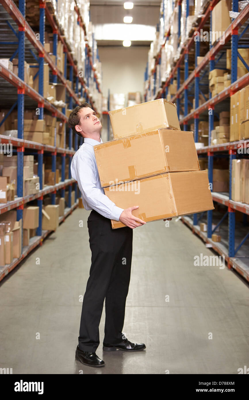 Man Carrying Boxes In Warehouse Stock Photo - Alamy
