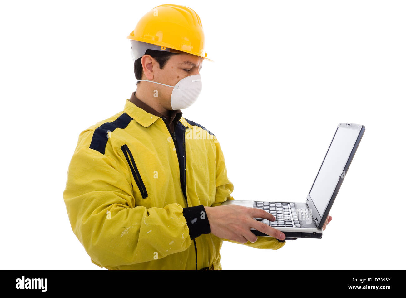 Engineer with workwear, helmet and mask looking to a computer Stock ...