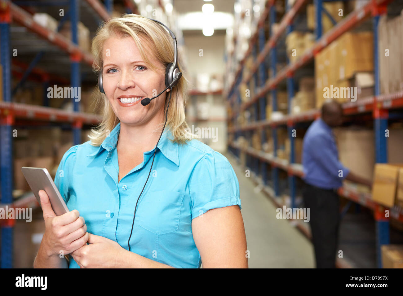 Businesswoman Using Headset In Distribution Warehouse Stock Photo - Alamy