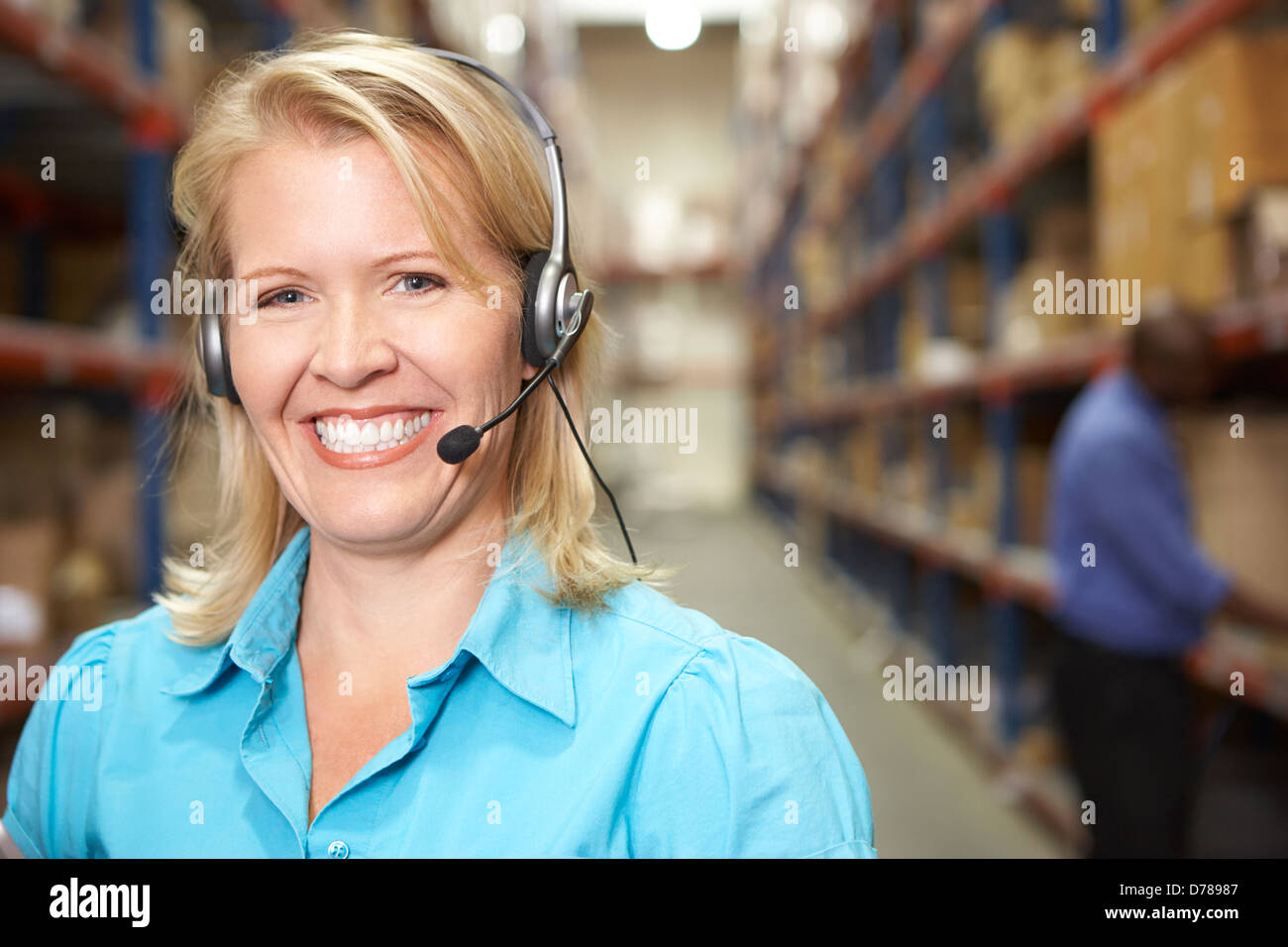 Businesswoman Using Headset In Distribution Warehouse Stock Photo - Alamy