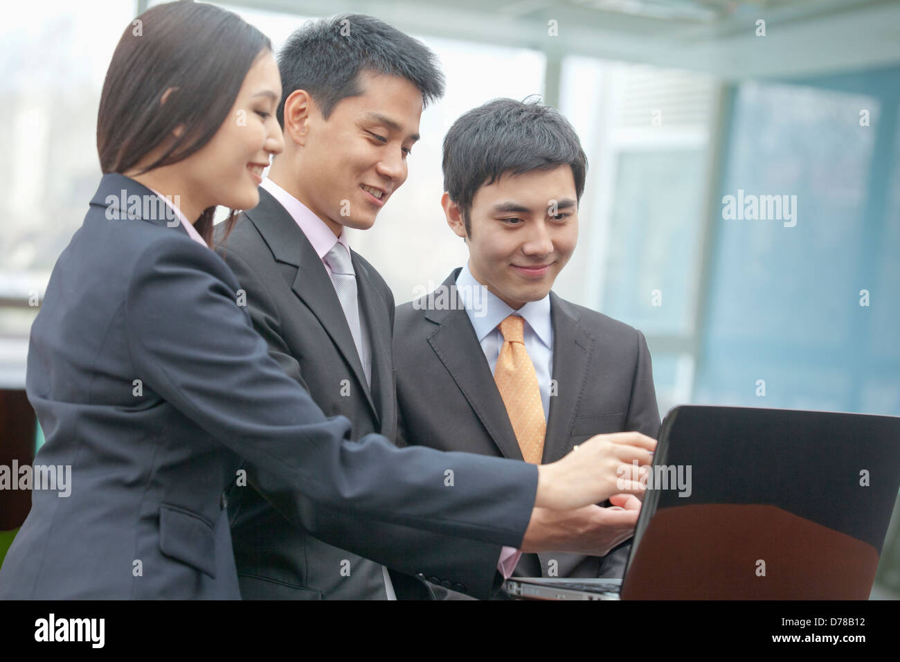 Three Business People Looking at Laptop Stock Photo - Alamy