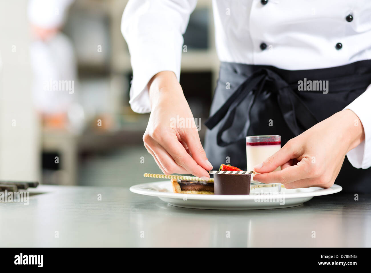 Cook, the female pastry chef, in hotel or restaurant kitchen cooking ...