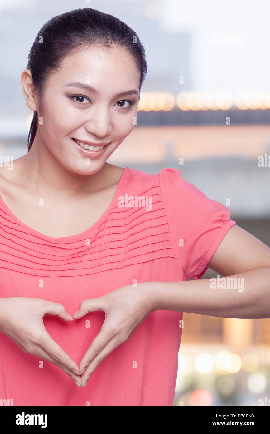 Young Woman Making Heart Sign with Hands Stock Photo - Alamy