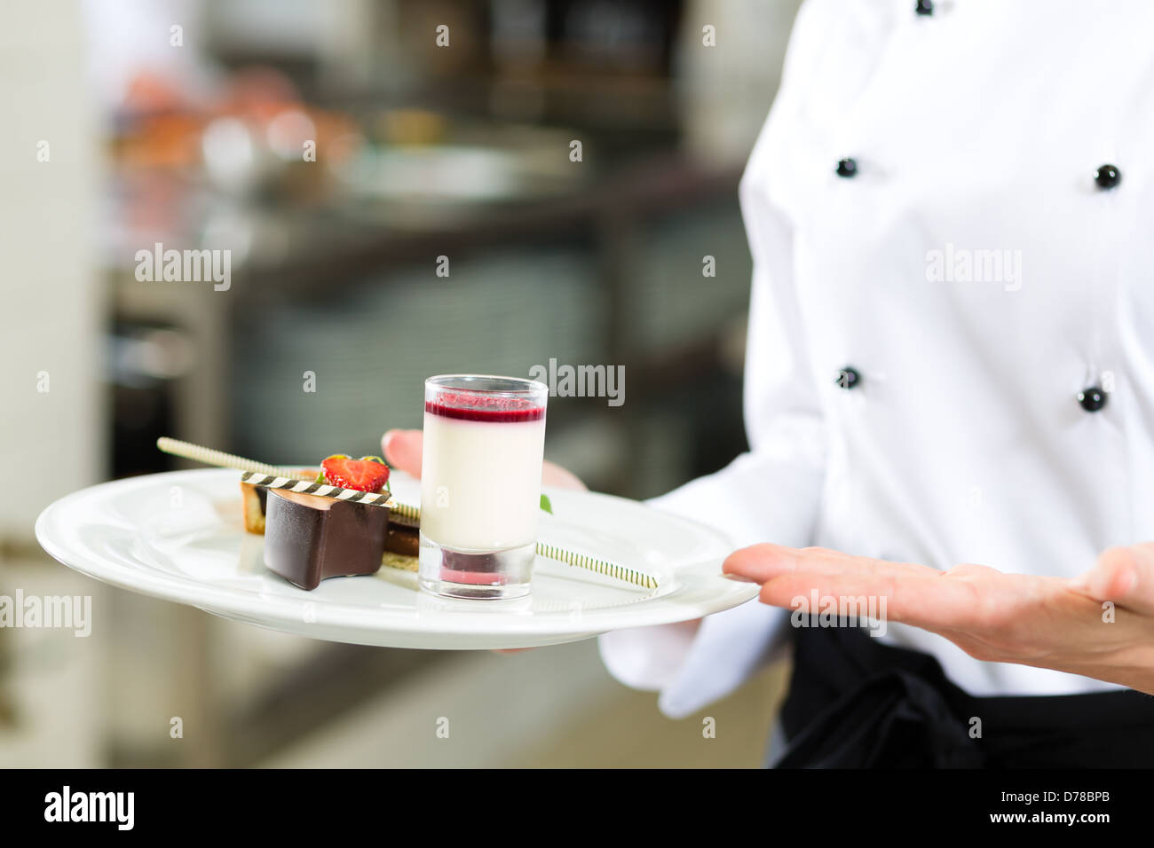 Cook, the female pastry chef, in hotel or restaurant kitchen cooking ...