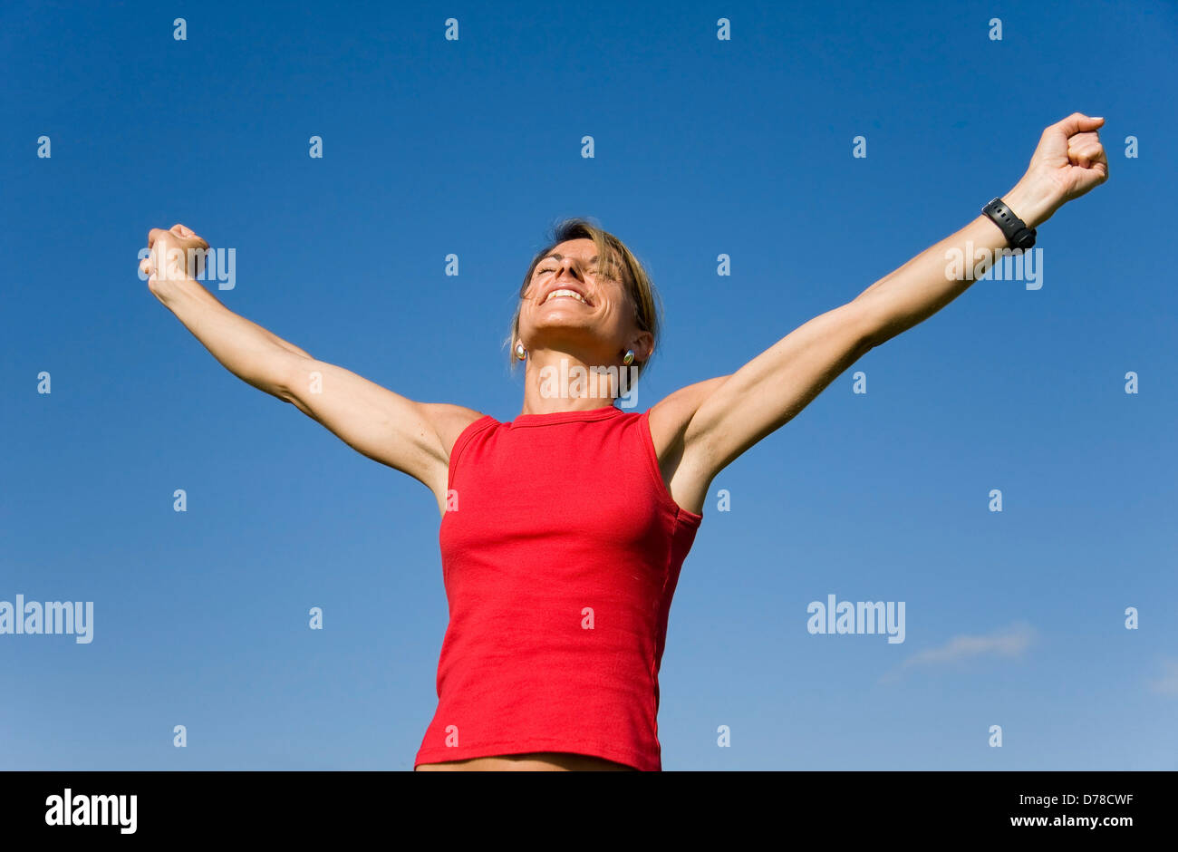 Beautiful women with her arms outstretched on a blue sky Stock Photo ...