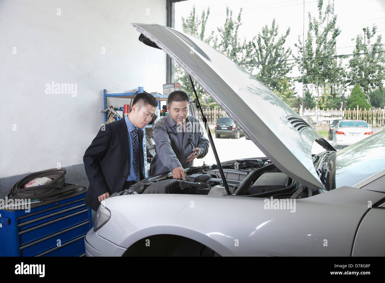 Garage Mechanic Explaining to Customer Stock Photo - Alamy