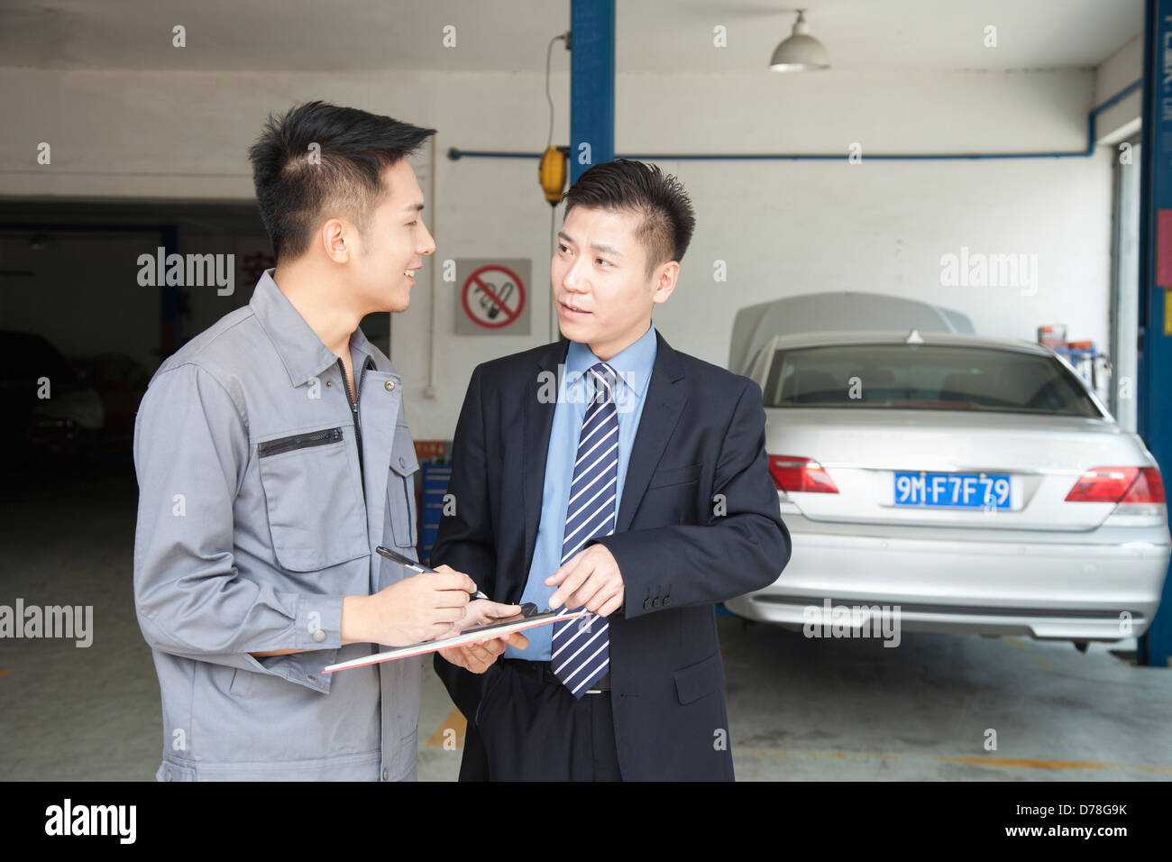 Garage Mechanic Explaining to Customer Stock Photo - Alamy